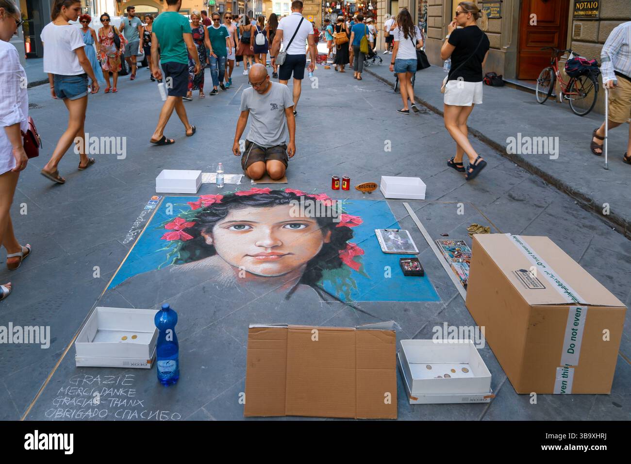 Street artist creating a chalk reproduction of famous painting on a ...