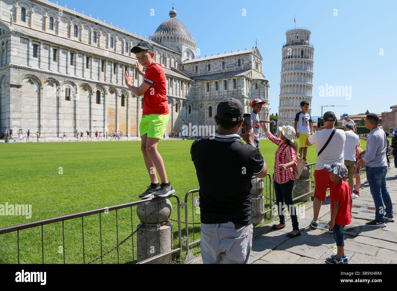 Tourists posing for photos in front of the Leaning Tower of Pisa, Italy ...