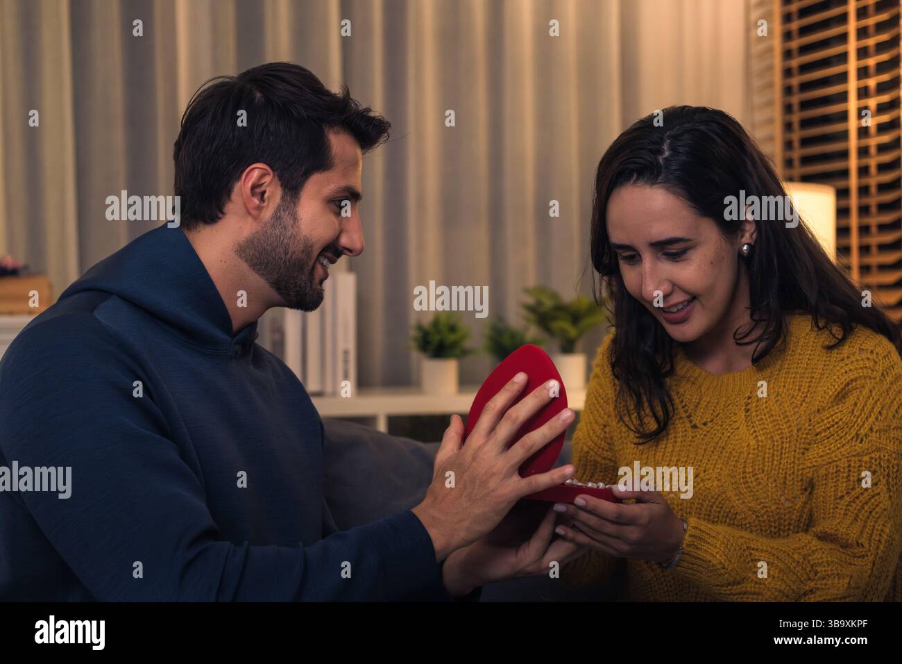 Romantic couple give a surprise gift at home, showing love ...