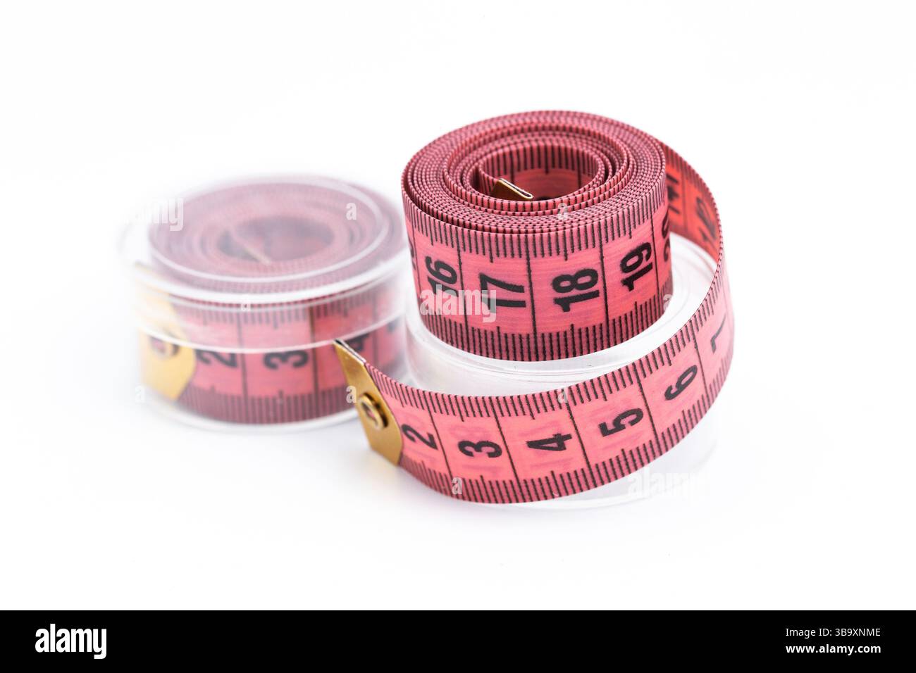 Tailor measuring tape closeup. Pink flexible ruler rolled in spiral. Centimeter scale for sewing ...