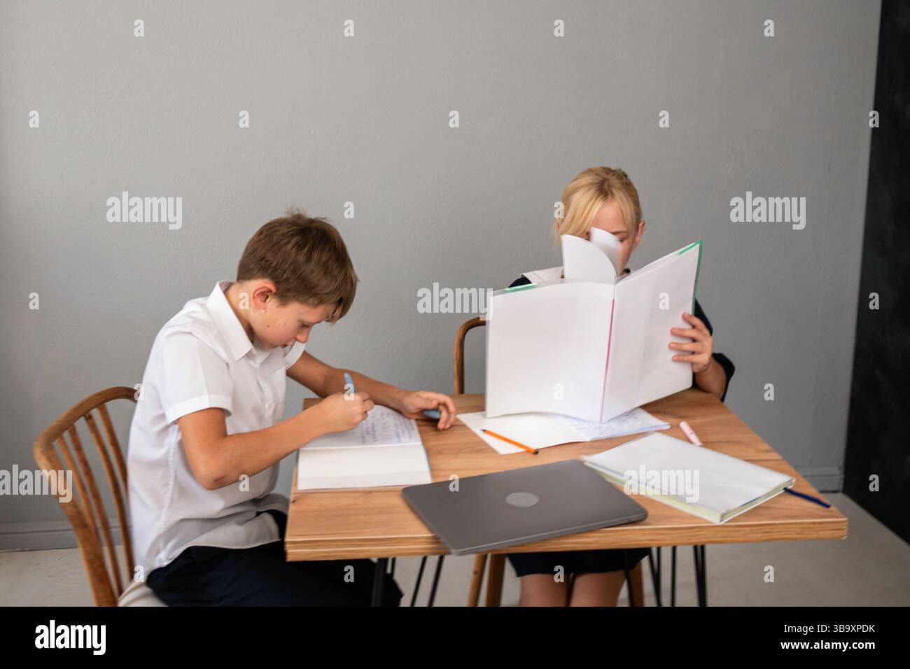 Children Homework Study Table - Two children sit at a table doing their ...