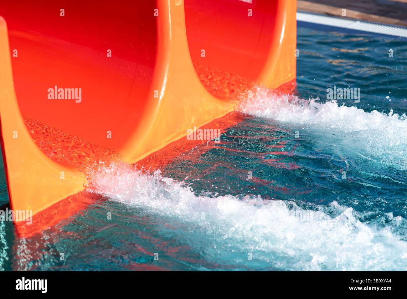 Two orange water slides in an amusement park. Summer water attractions ...