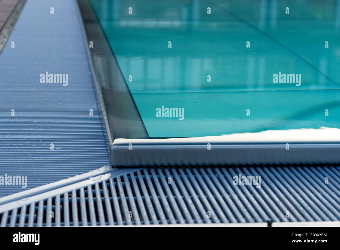 View of the corner of a swimming pool with turquoise water and a mesh ...