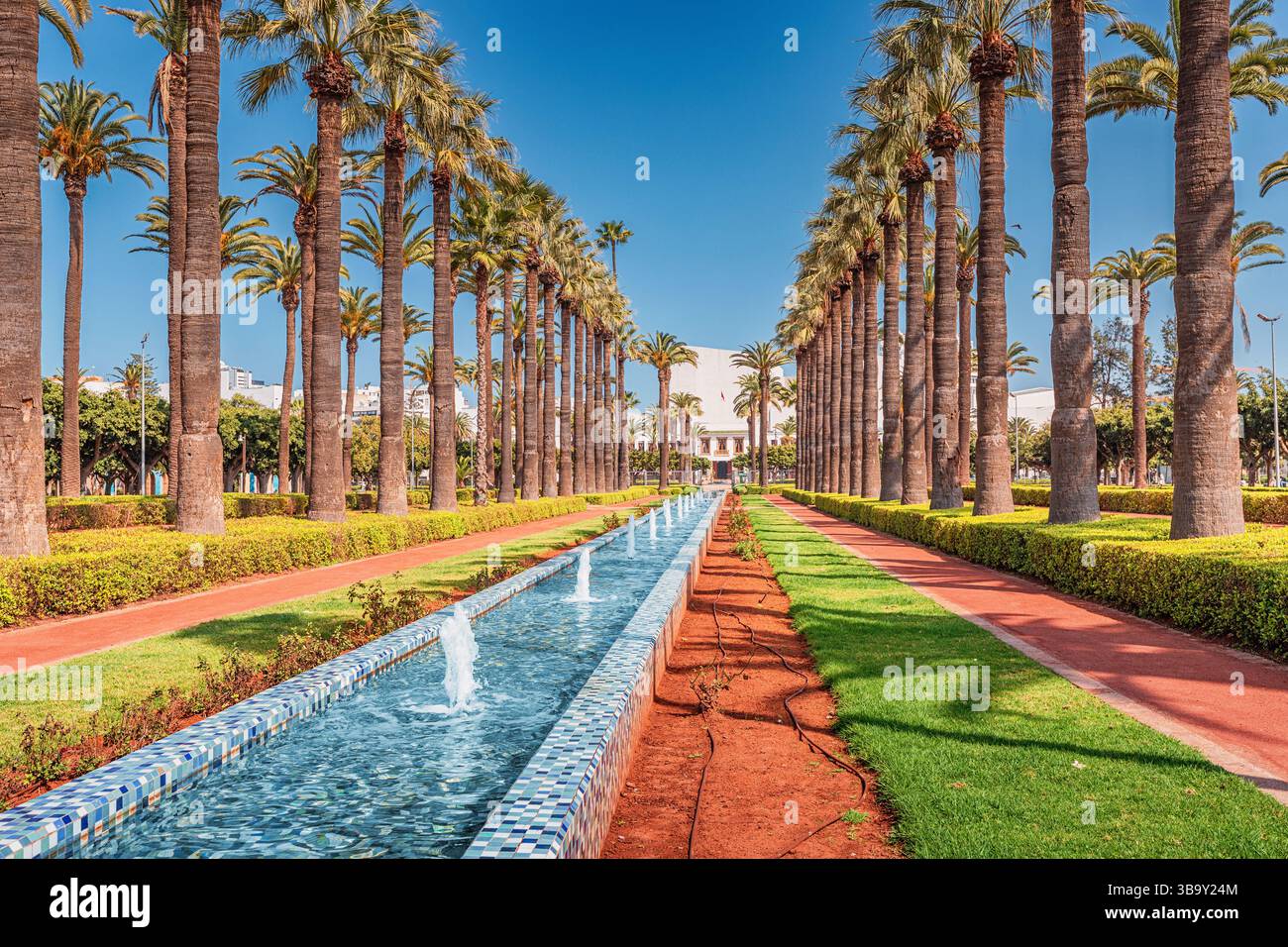 Scenic view of the manicured hedges, palm trees, and water features ...