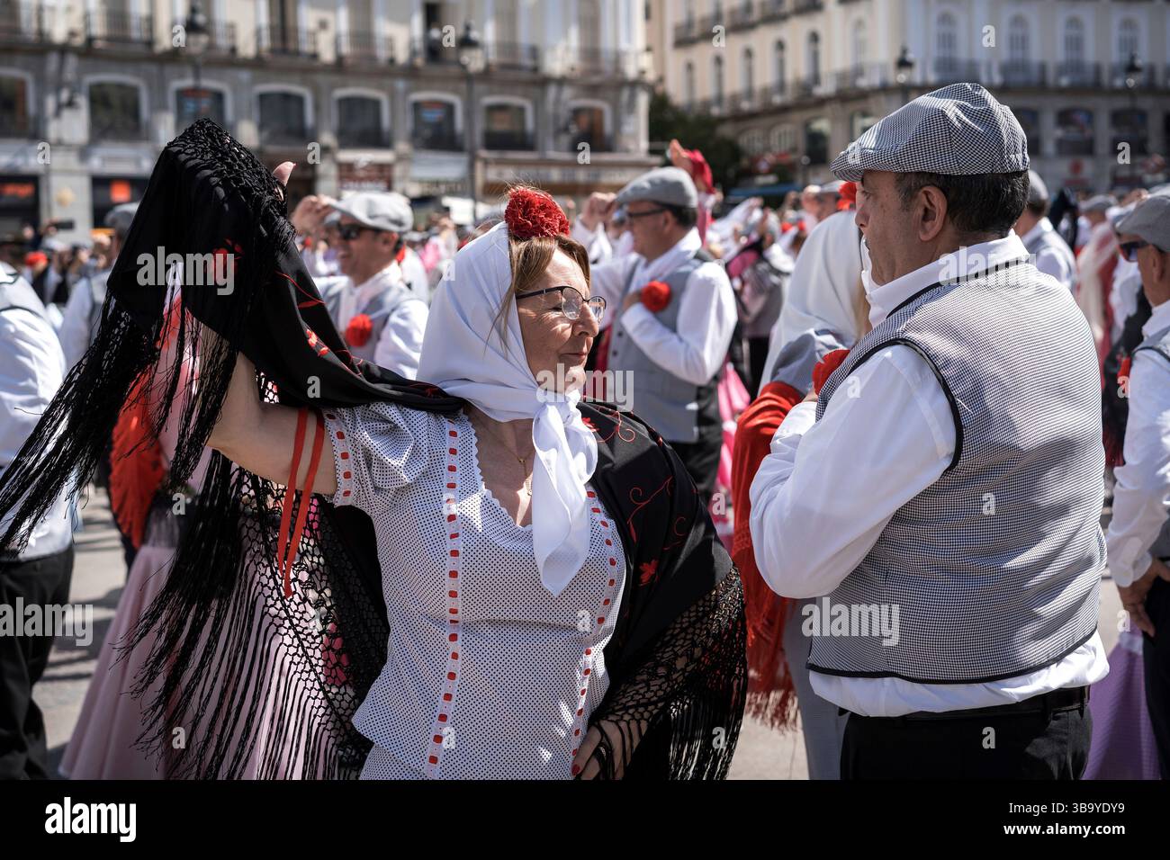 Several people dance the chotis during the pasacalles castizo 'Bailando ...