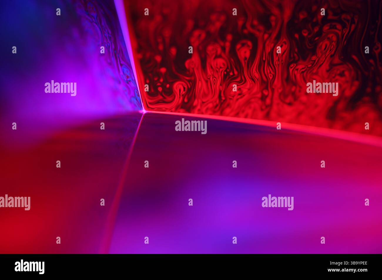 Red and purple fluid reflections on black background, liquid surface ...