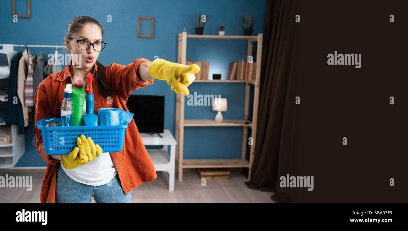 Angry woman pointing at screen with finger holding basket of detergents ...