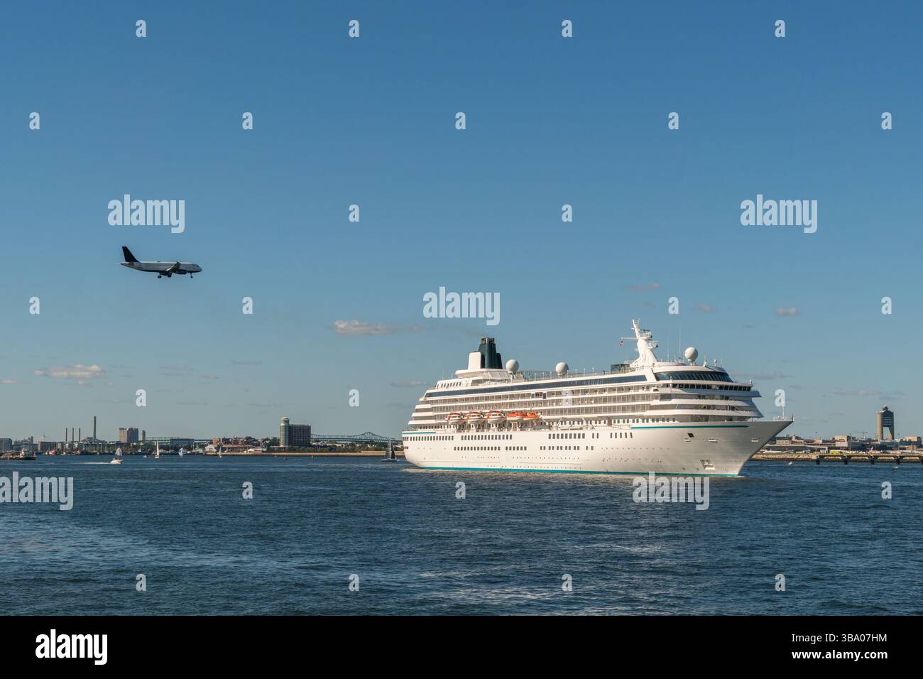 Cruise ship sailing from city port with passenger jet airliner overhead ...