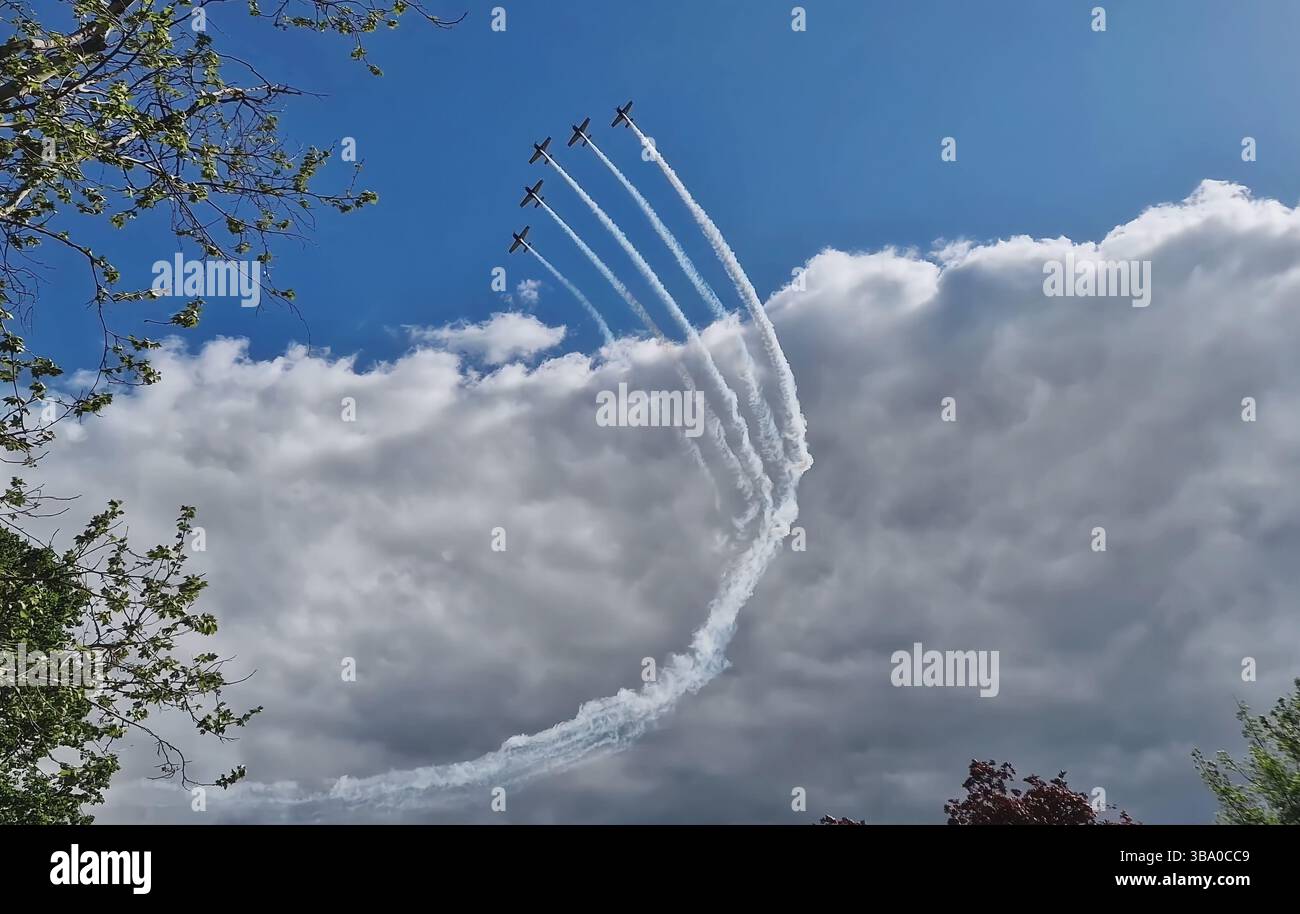 Air show with five airplanes flying in formation with white smoke ...