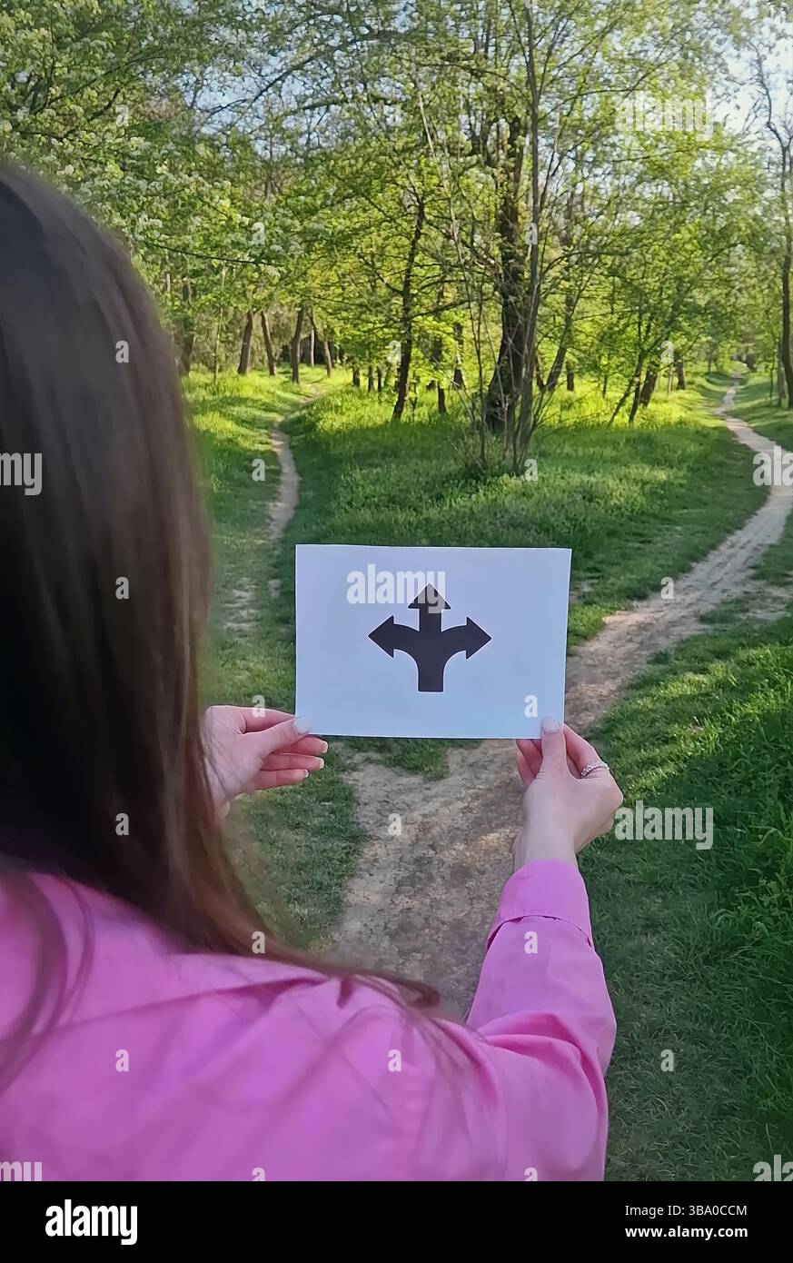 Woman hands holding a paper with arrows pointing left, right, and ...