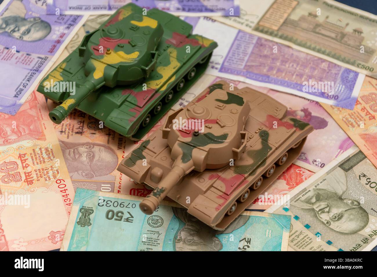 Toy tanks in the background of Indian banknotes as a symbol of military ...