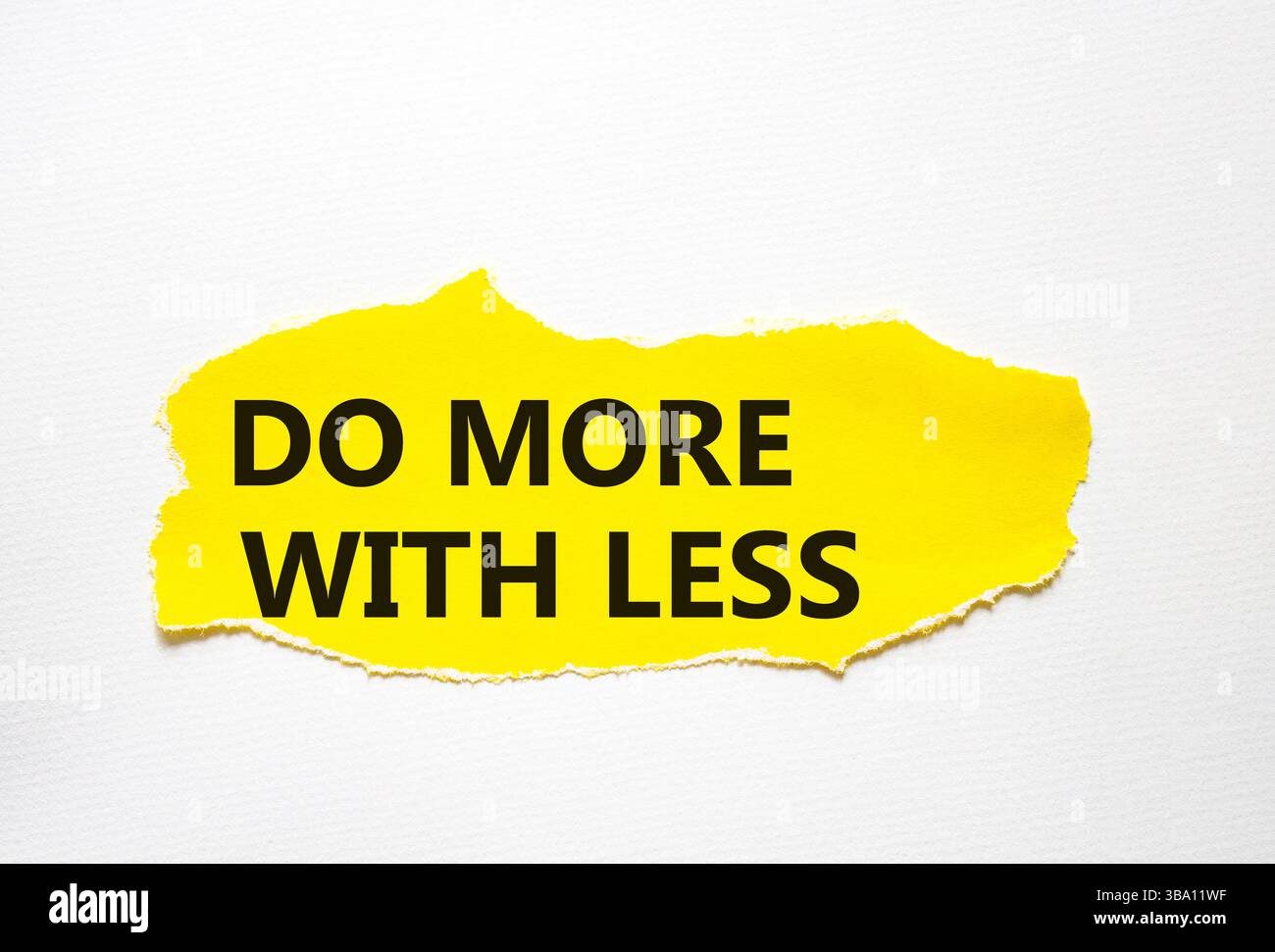 Do more with less symbol. Concept words Do more with less on torn yellow paper. Beautiful white ...