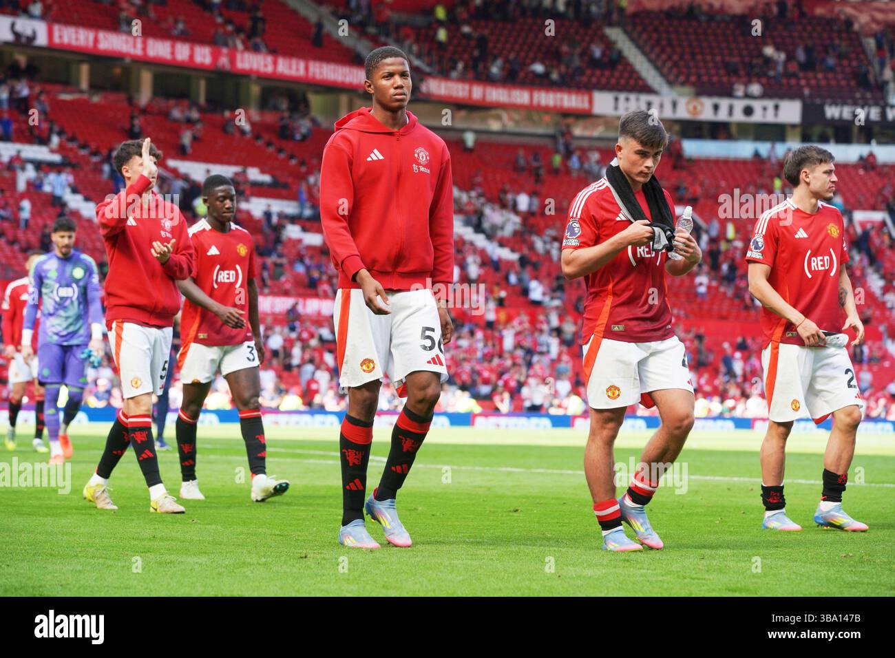 Manchester United players walk on the pitch in dejection at the end of ...