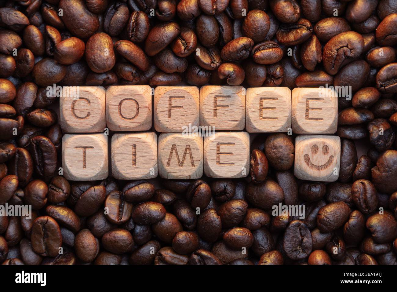 Wooden blocks spell coffee time on roasted coffee beans background ...