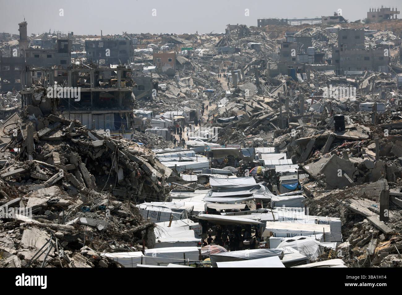 Displaced Palestinians taking refuge in makeshift tents and heavily ...