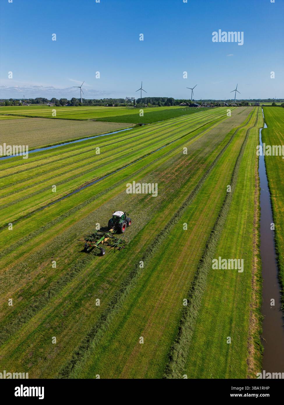 Aerial view of a Dutch rural landscape with green fields, a tractor ...