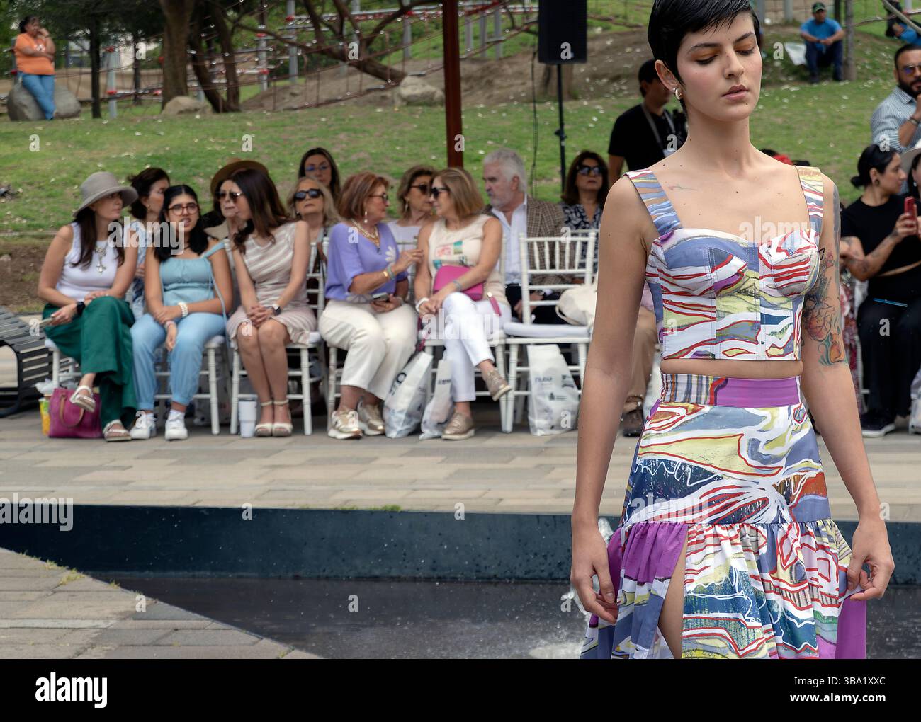 A model parades in a park in a fashion show for models with ...