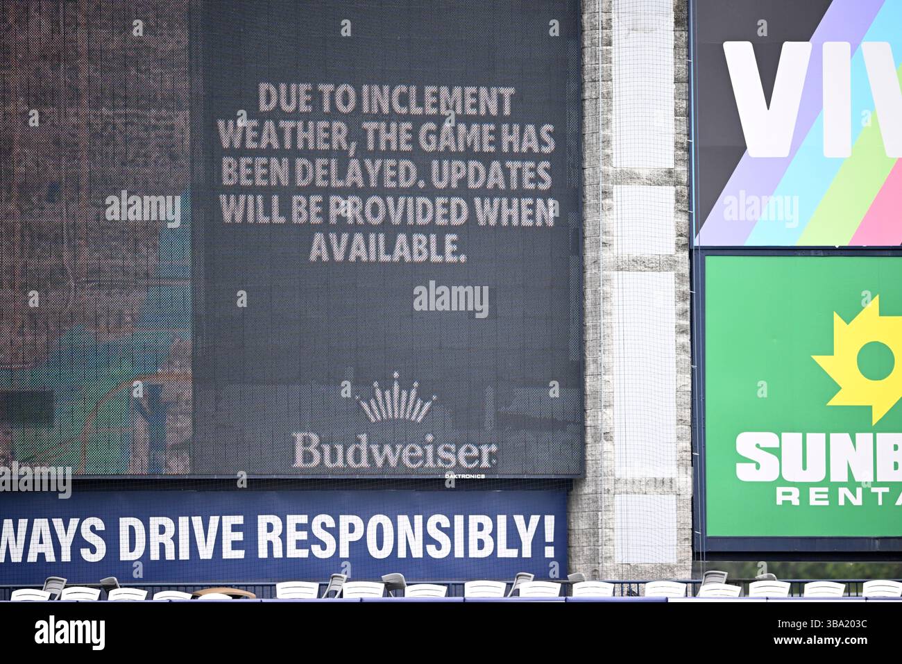 A weather delay advisory is displayed on the stadium scoreboard before ...