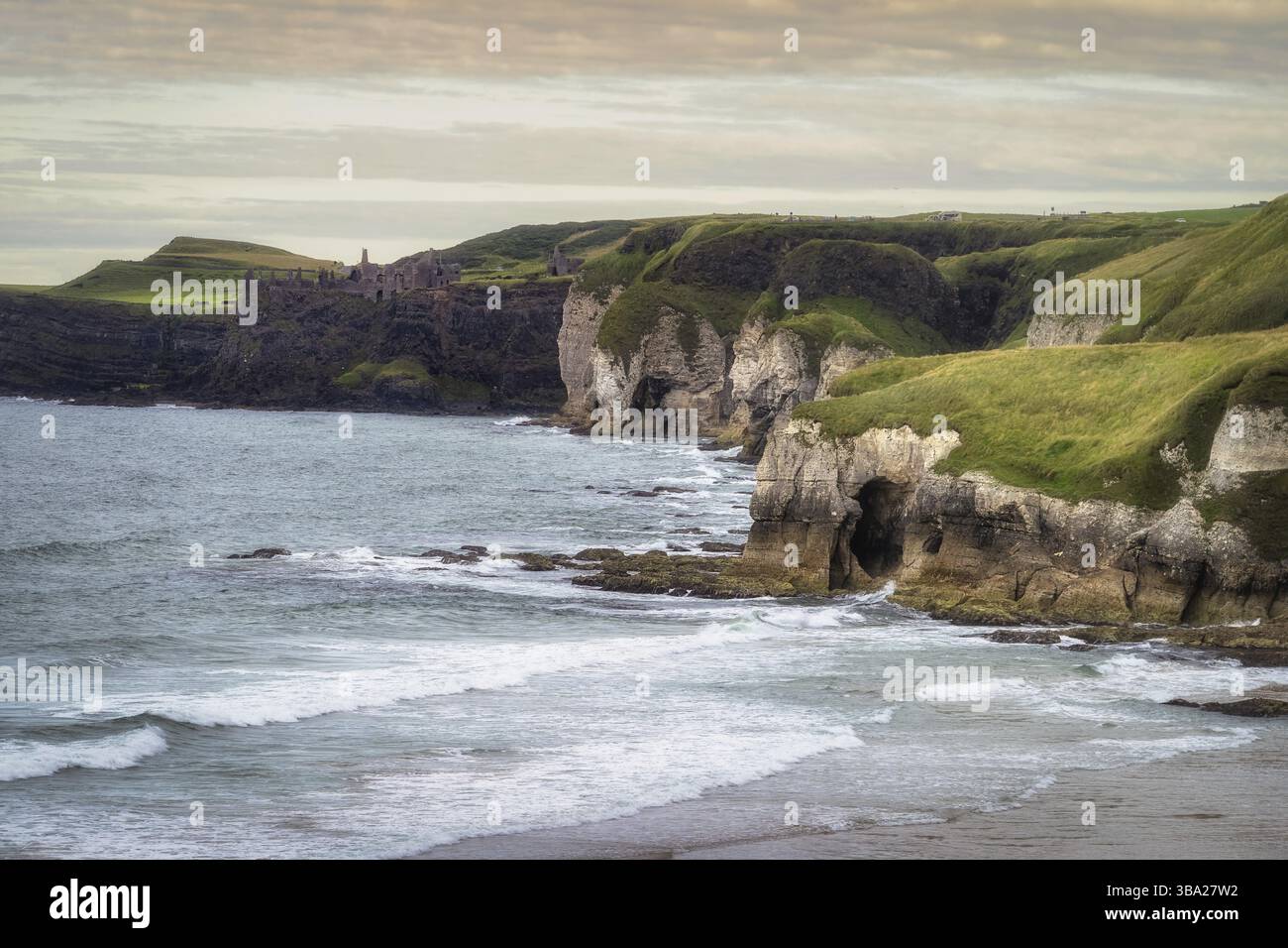 Dunluce Castle on the edge of cliff and limestone rock formations on ...