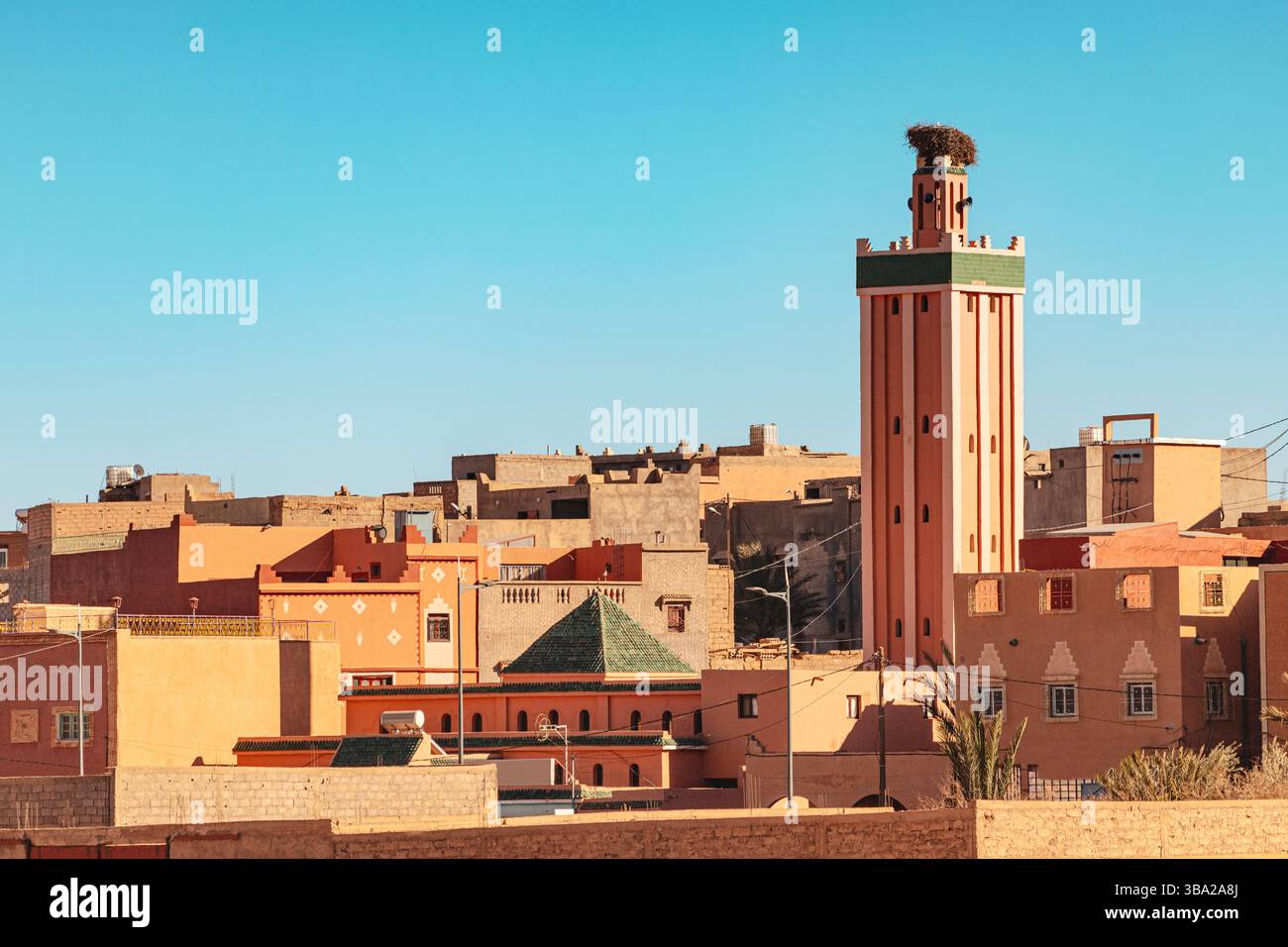 Traditional Moroccan architecture featuring a prominent minaret rising ...