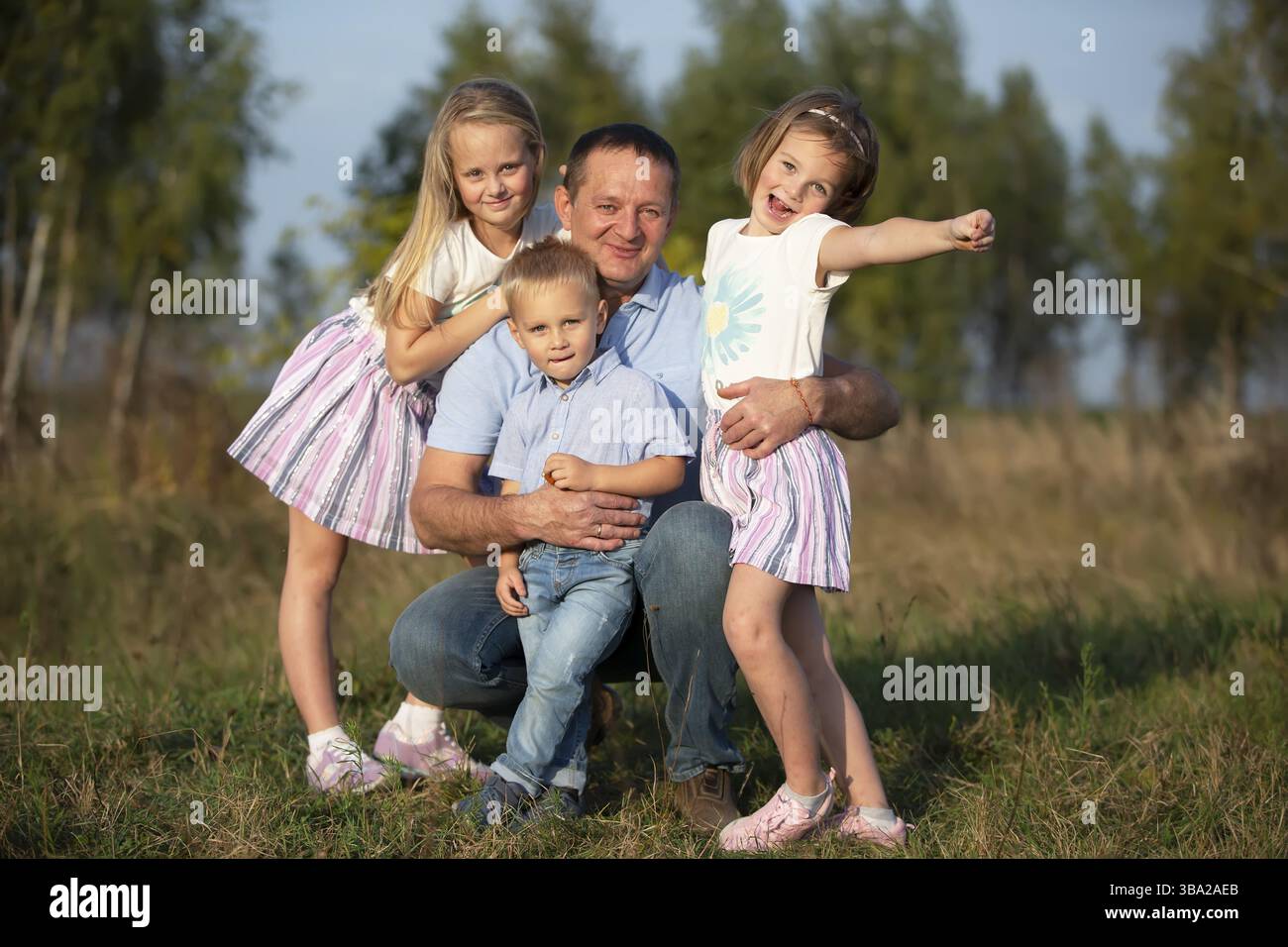 Dad with daughters and son looking into the camera. Happy father and ...