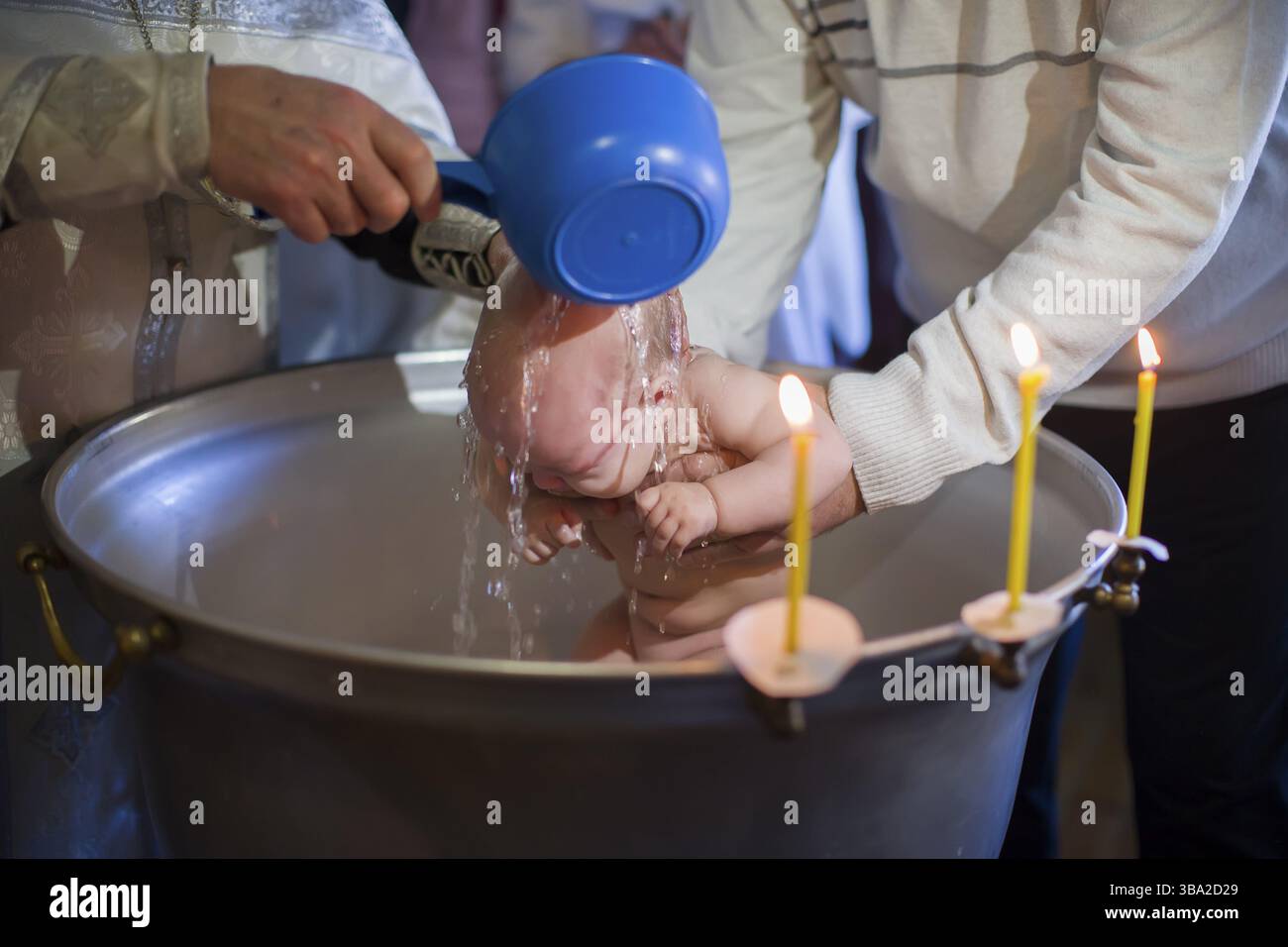 Priest pours water on the infant at baptism. Orthodox rite of baptism ...