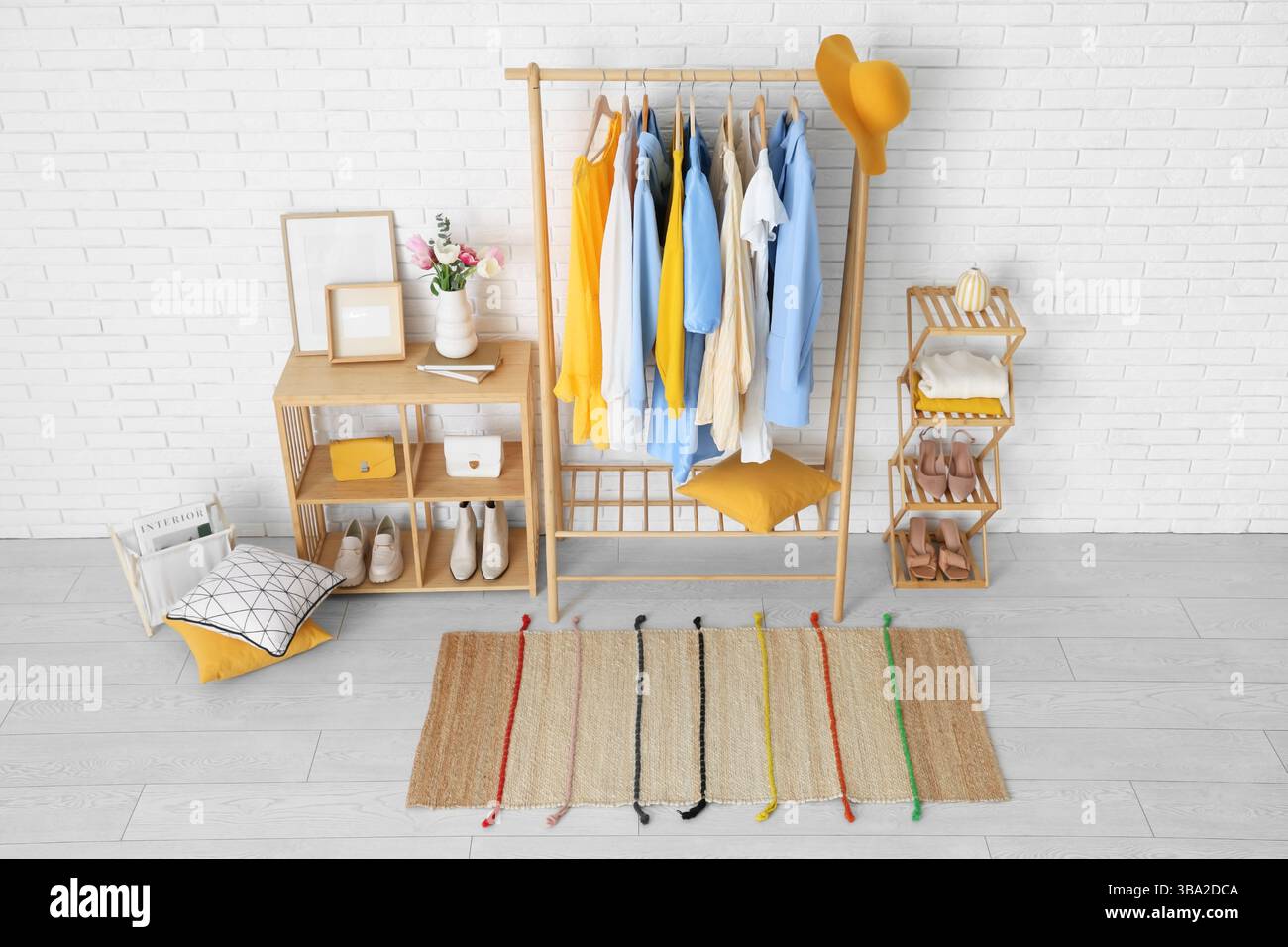 Interior of light dressing room with clothes rack and shelving units ...