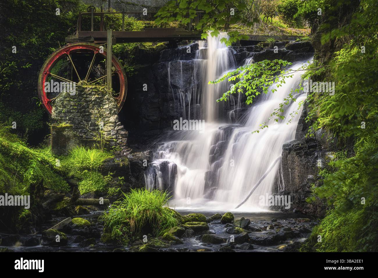 Vintage red waterwheel with waterfall at spring in Glenariff Forest ...