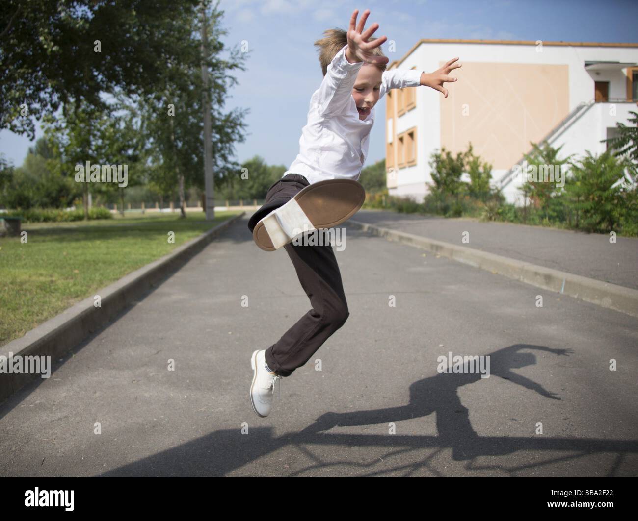 The boy jumps high. A pupil of primary classes on a street change Stock ...