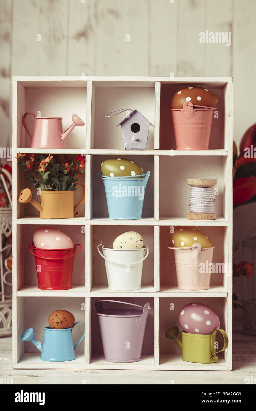 Colourful Eggs in miniature buckets and cans in shadowbox. Spring and ...