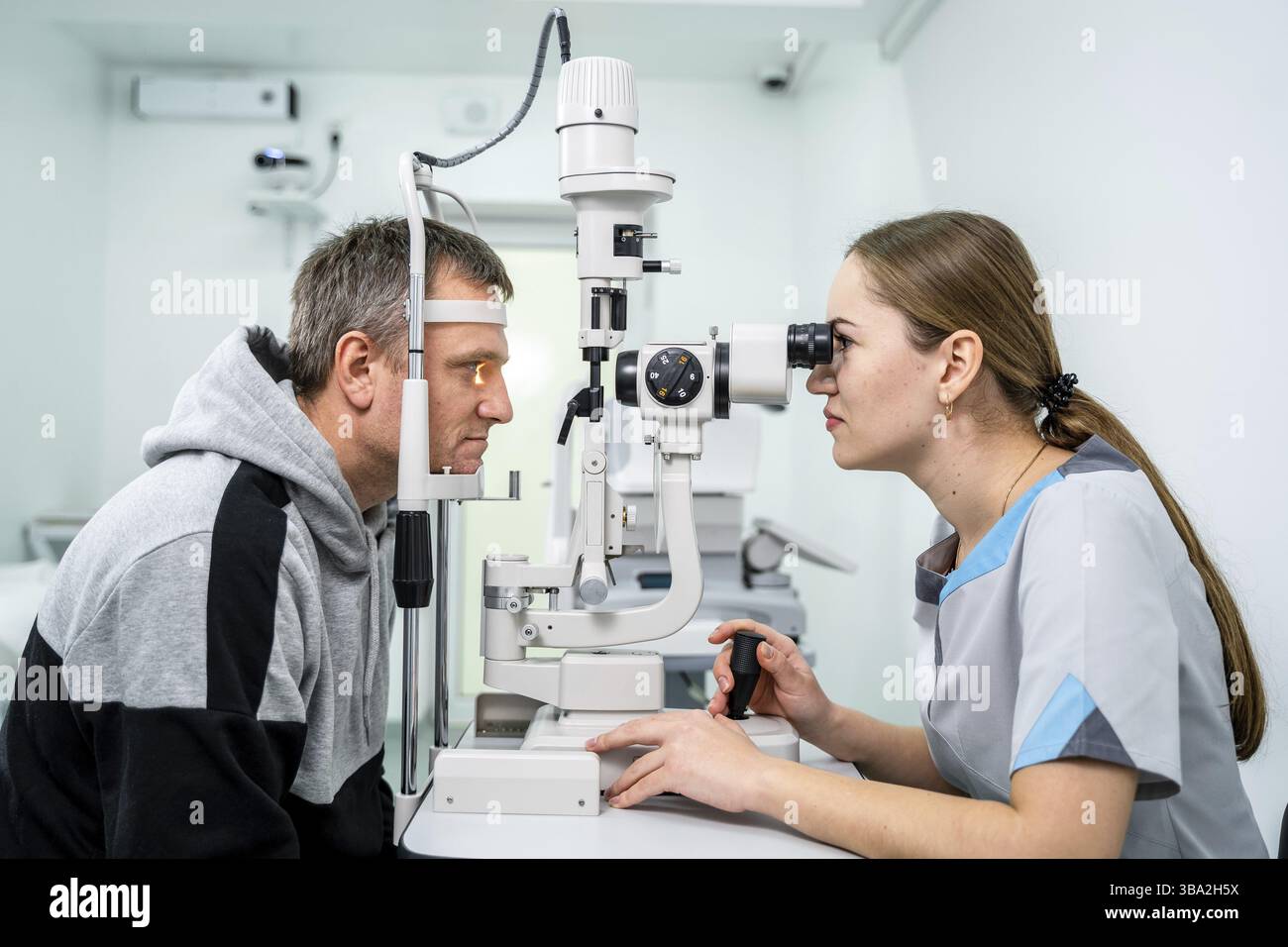Doctor and patient in ophthalmology clinic. Male patient checking ...