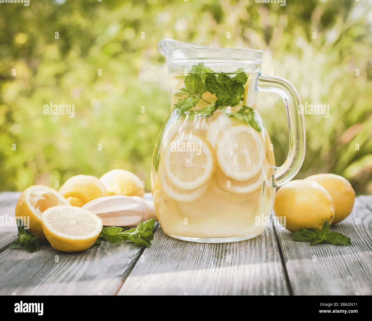 Preparation of the lemonade drink. Lemonade in the jug and lemons with ...