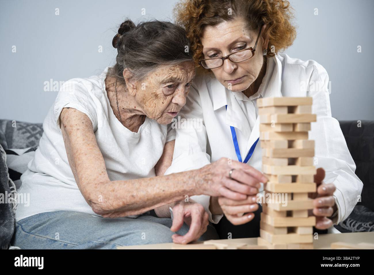 Mature doctor conducting session, therapy for senior patient in nursing ...
