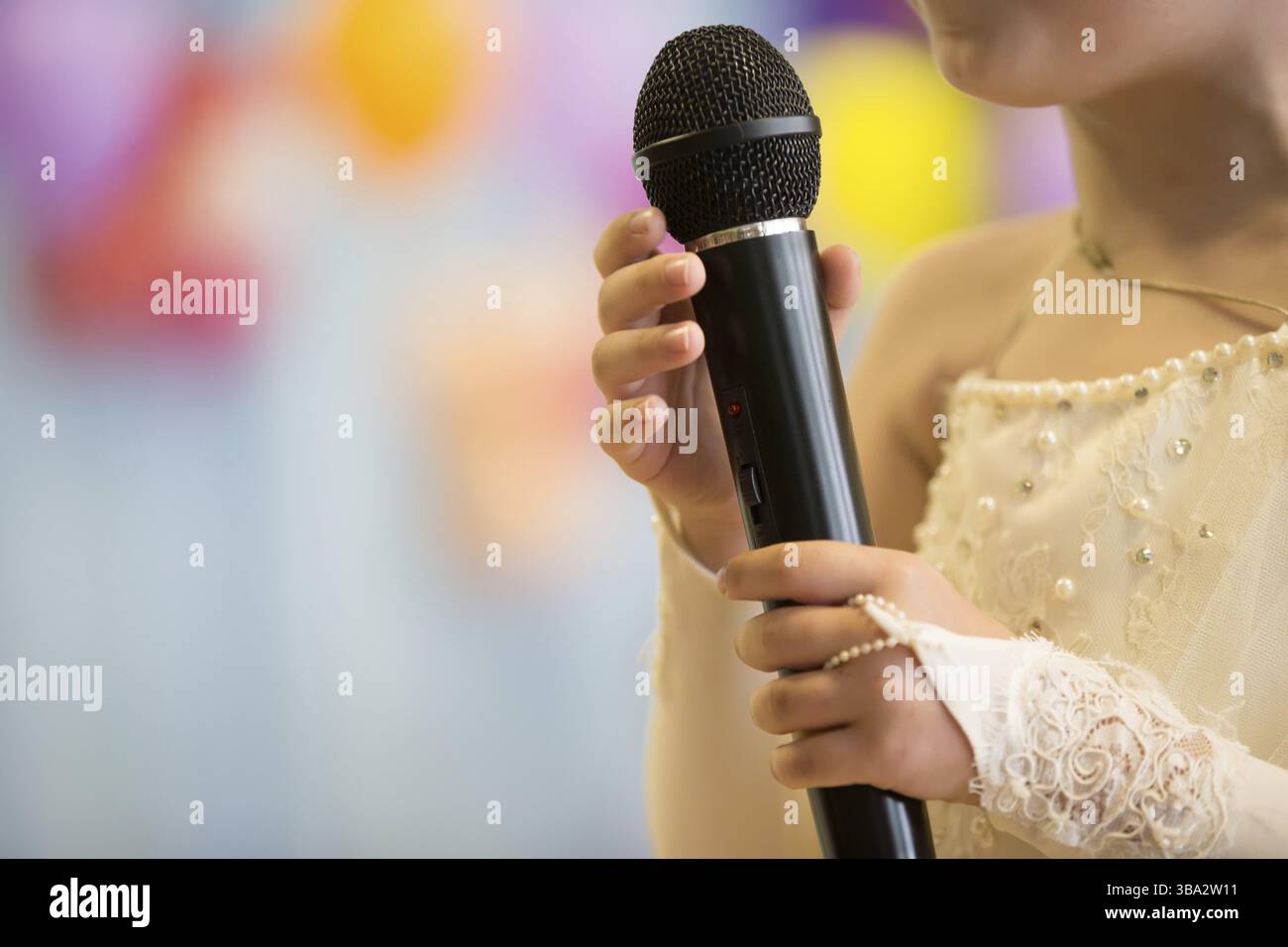 Children's hands hold a microphone Stock Photo - Alamy