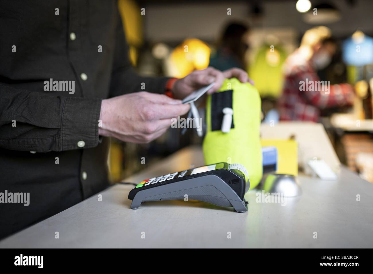 Salesman holds payment terminal while holding receipt for completing ...