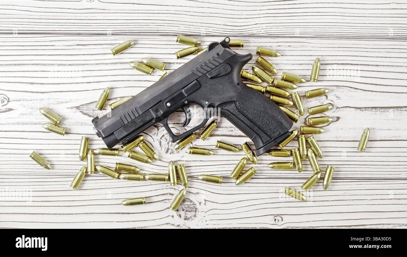 Top down view - modern black simple gun and yellow brass ammunition ...