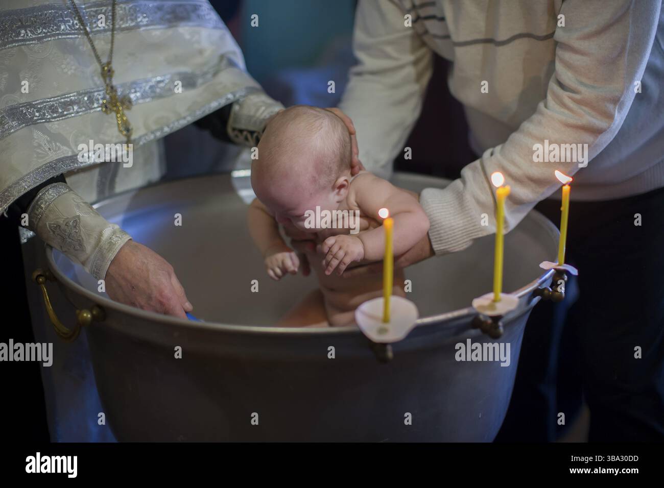 Priest pours water on the infant at baptism. Orthodox rite of baptism ...