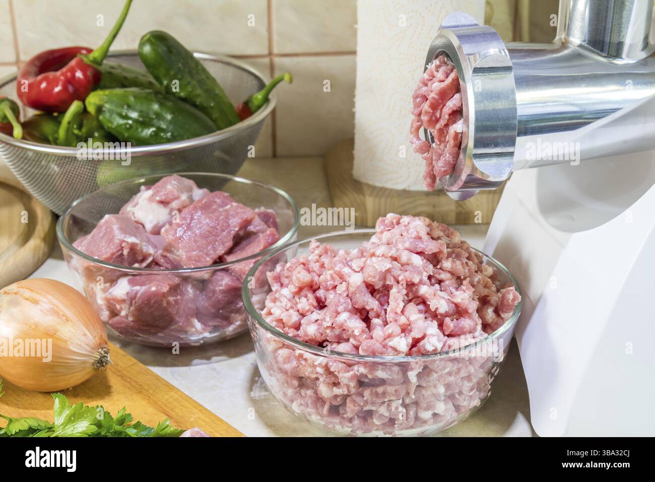 Home electric meat-grinder is making pork stuffing in a modern kitchen ...