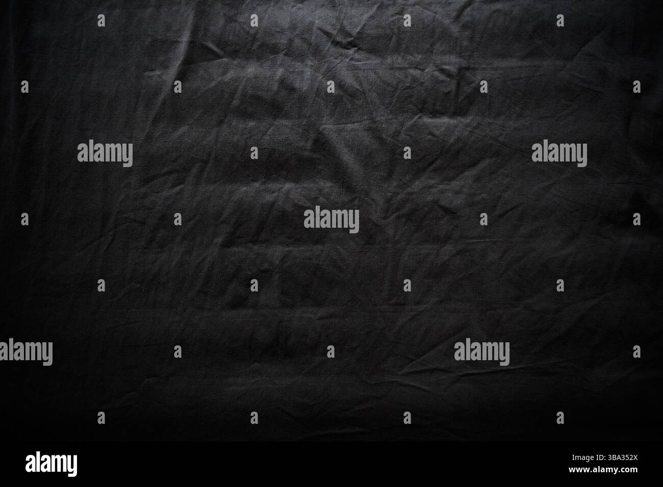 Texture of dark black crumpled and creased fabric material as ...