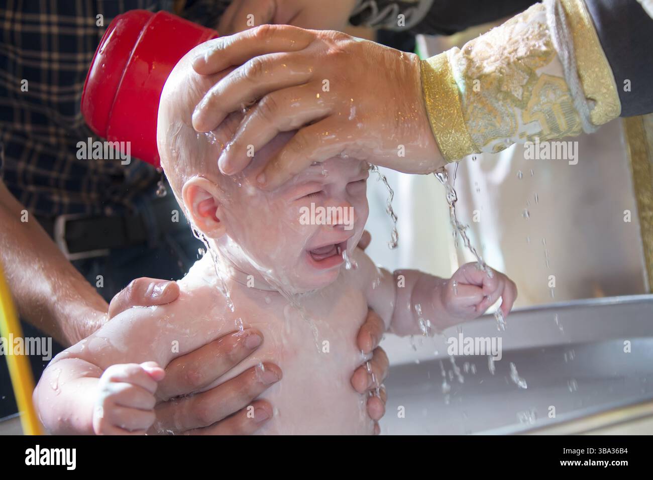 Priest pours water on the infant at baptism. Orthodox rite of baptism ...