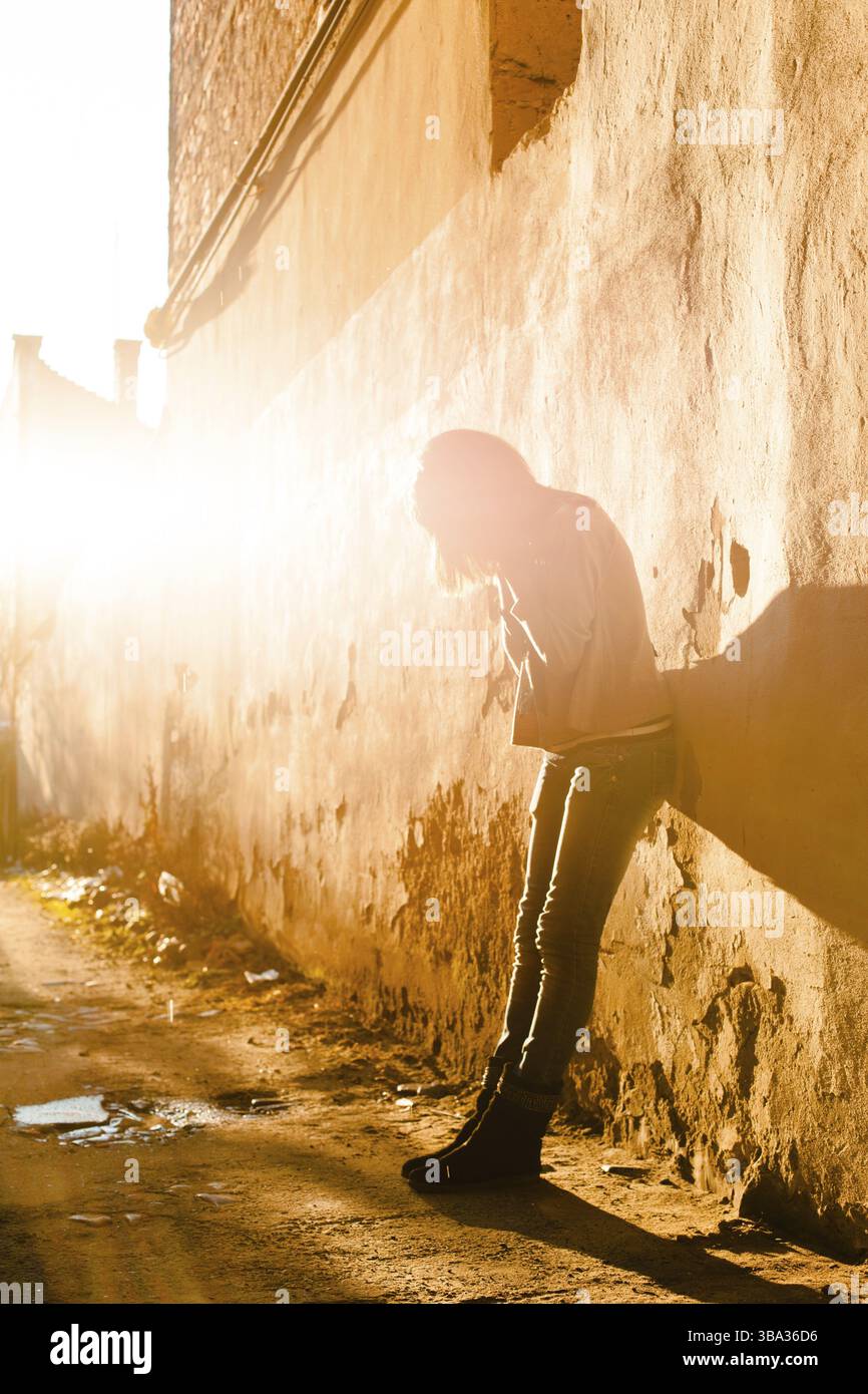 Sad teenage girl crying and praying with hope in dirty poor ghetto ...