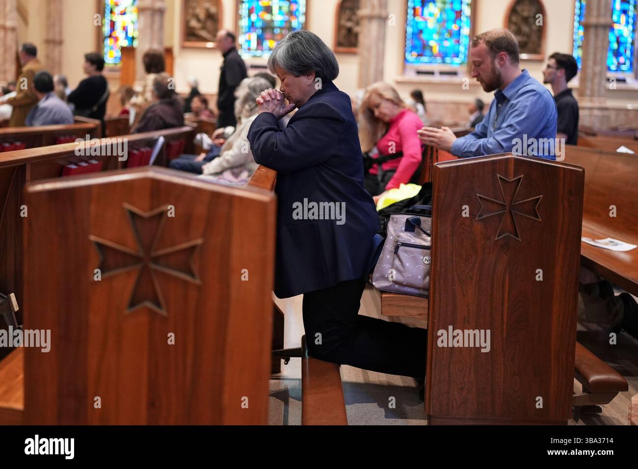 Grace Mellor prays in a pew during a Mass at Holy Name Cathedral in ...