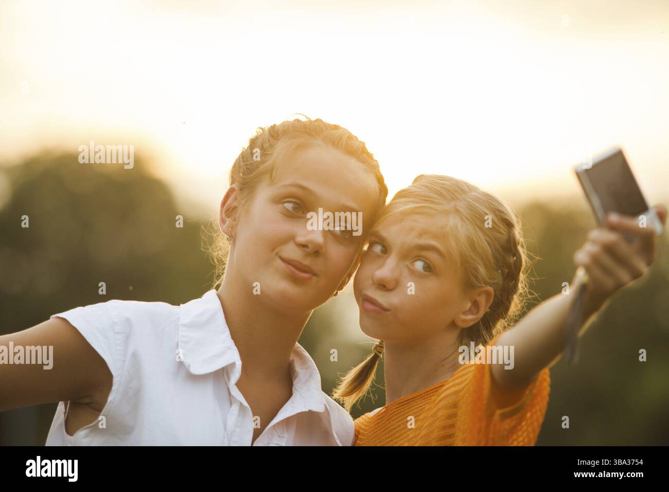 Friends taking a self portrait outdoor. Two girls makes selfie in the ...