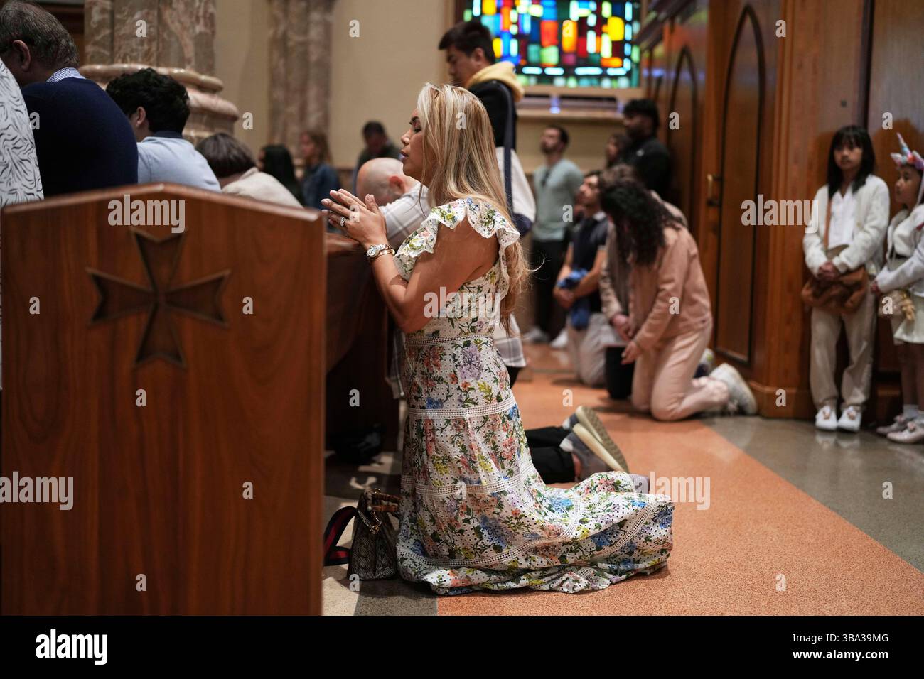 Angela Hurtado kneels down to pray during a mass at Holy Name Cathedral ...