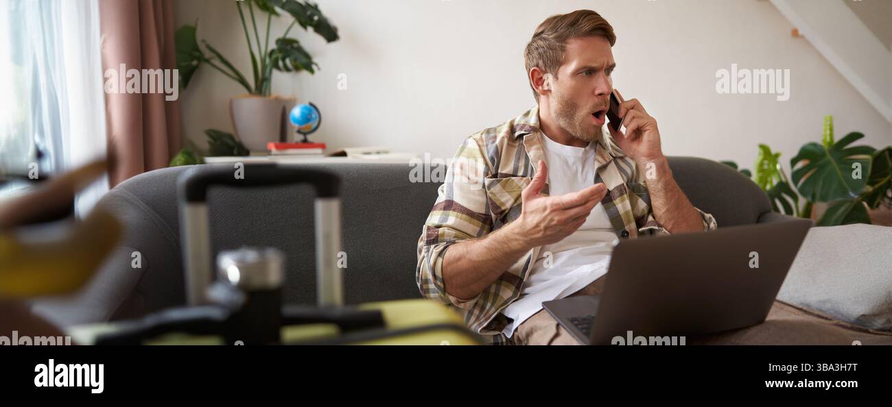 Portrait of angry man arguing over the phone, has laptop opened on his ...