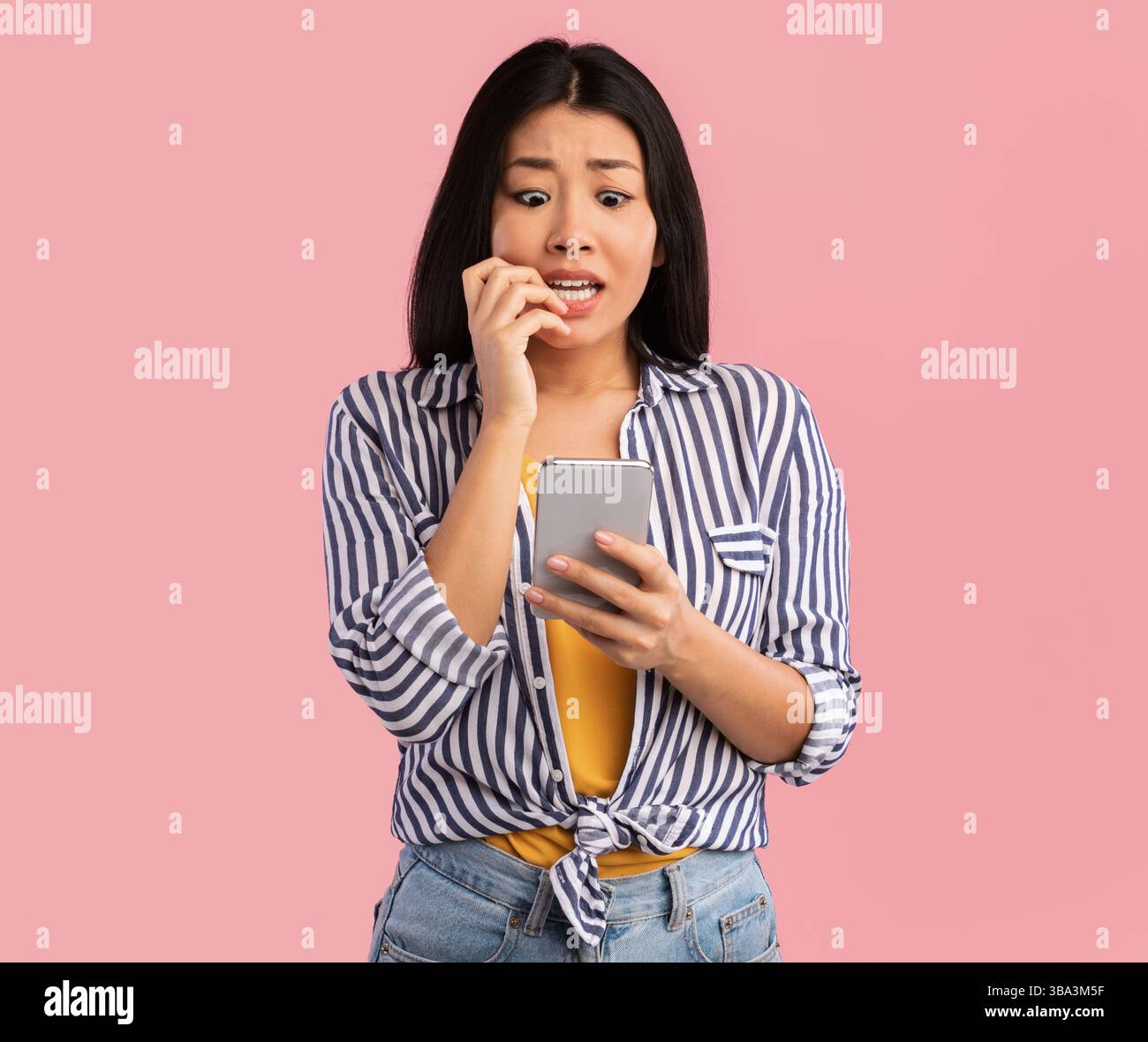 Anxious scared asian woman looking at phone seeing bad news Stock Photo ...
