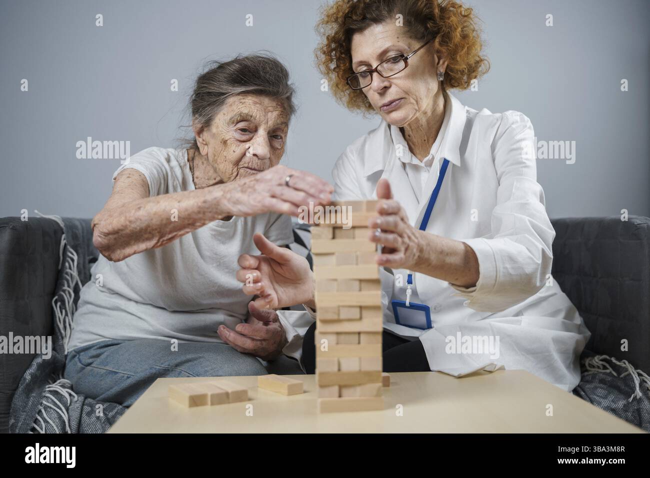 Mature doctor conducting session, therapy for senior patient in nursing ...