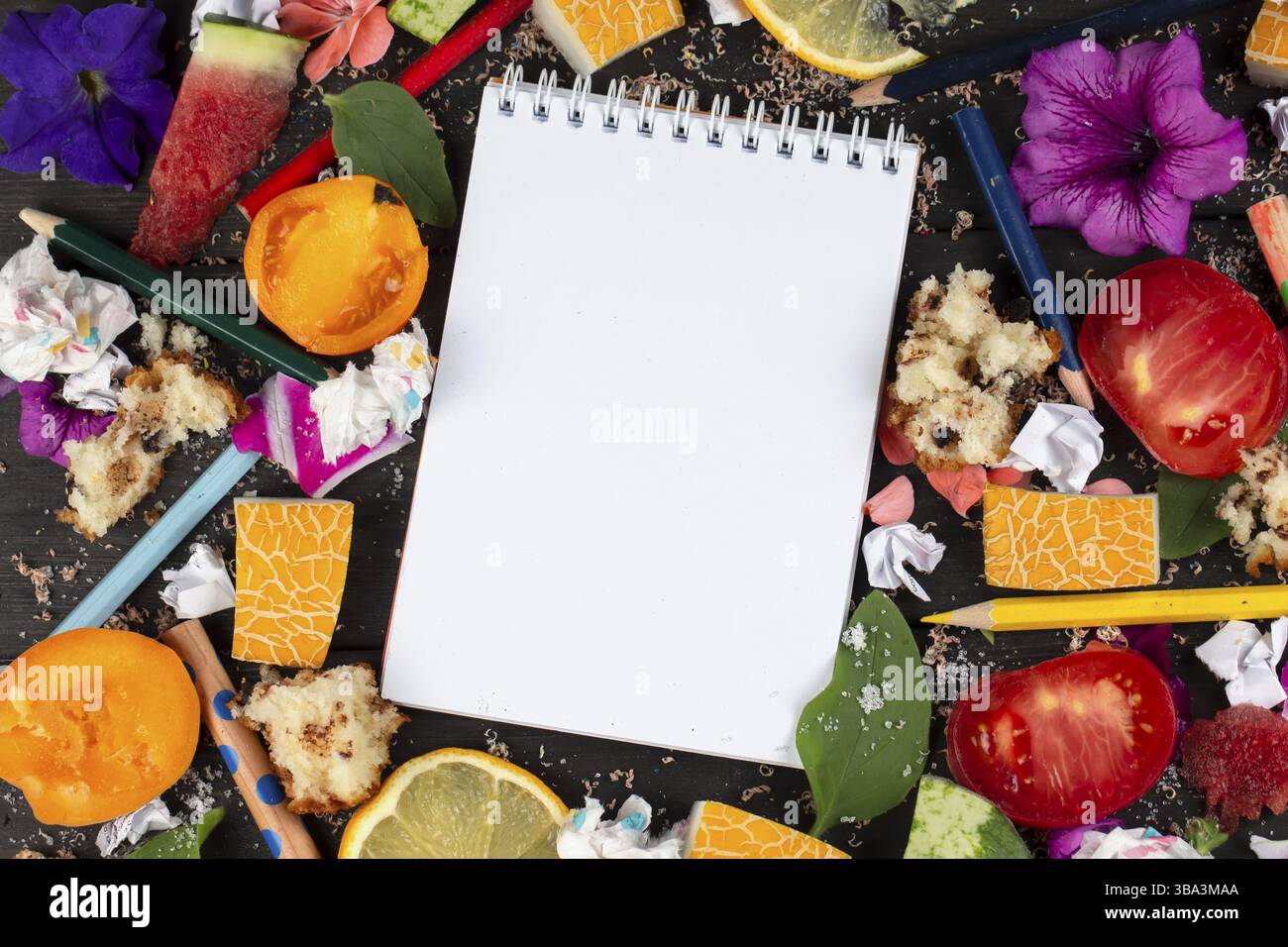 Paper notebook with blank pages, crumpled paper balls and crayons ...