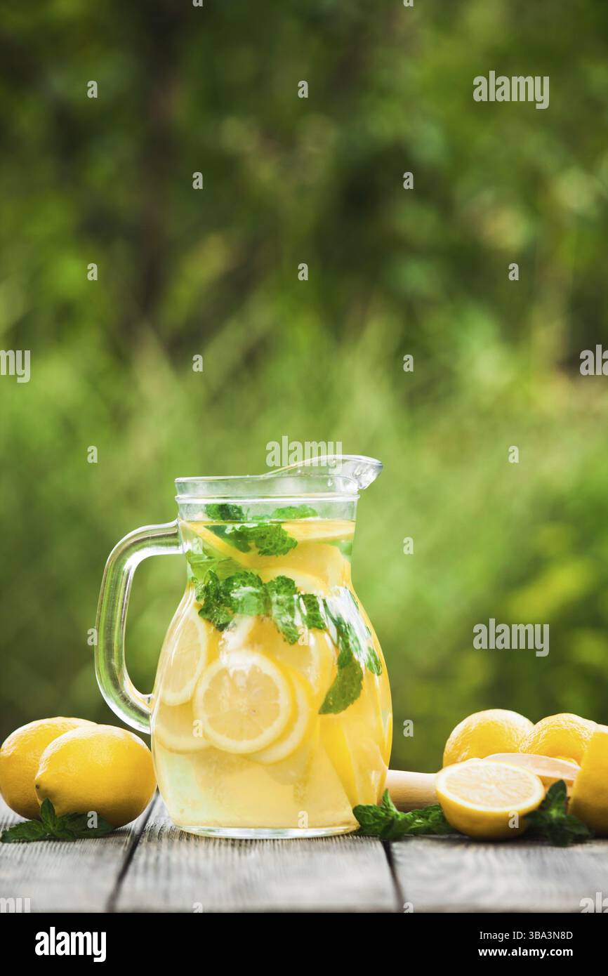 Preparation of the lemonade drink. Lemonade in the jug and lemons with ...