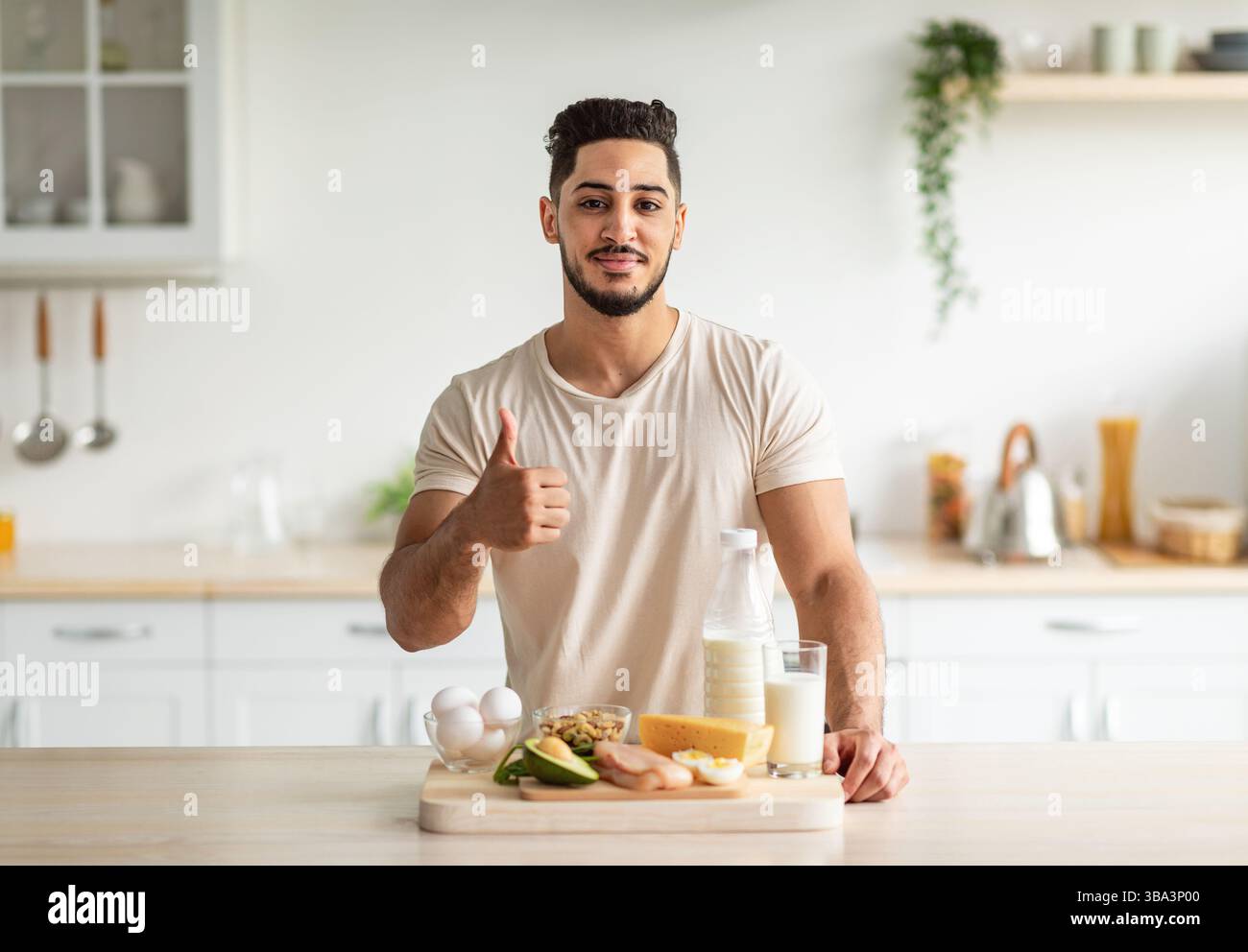 Portrait of fit young Arab man offering healthy products rich in ...